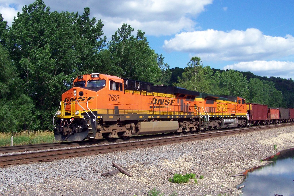 BNSF 7637 pulls a lengthy train of empty ballast cars north past Marina Road